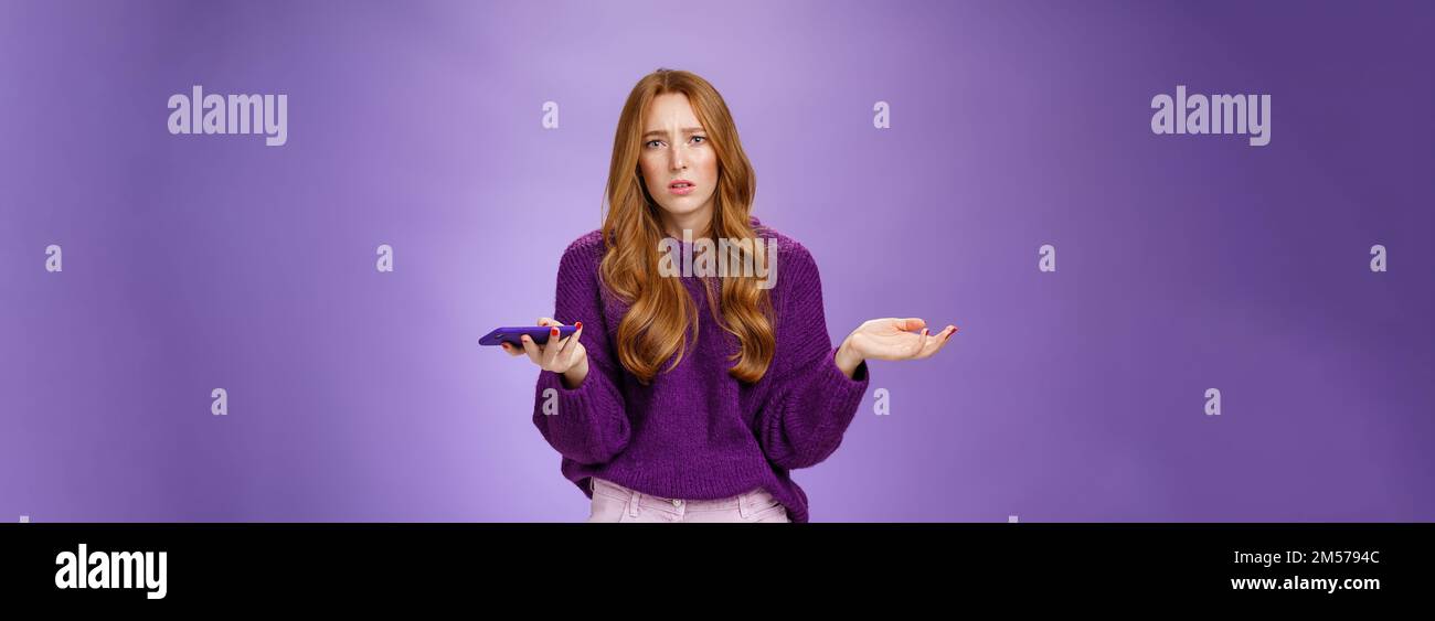 Clueless and sad cute redhead woman spread hands sideways frowning ...