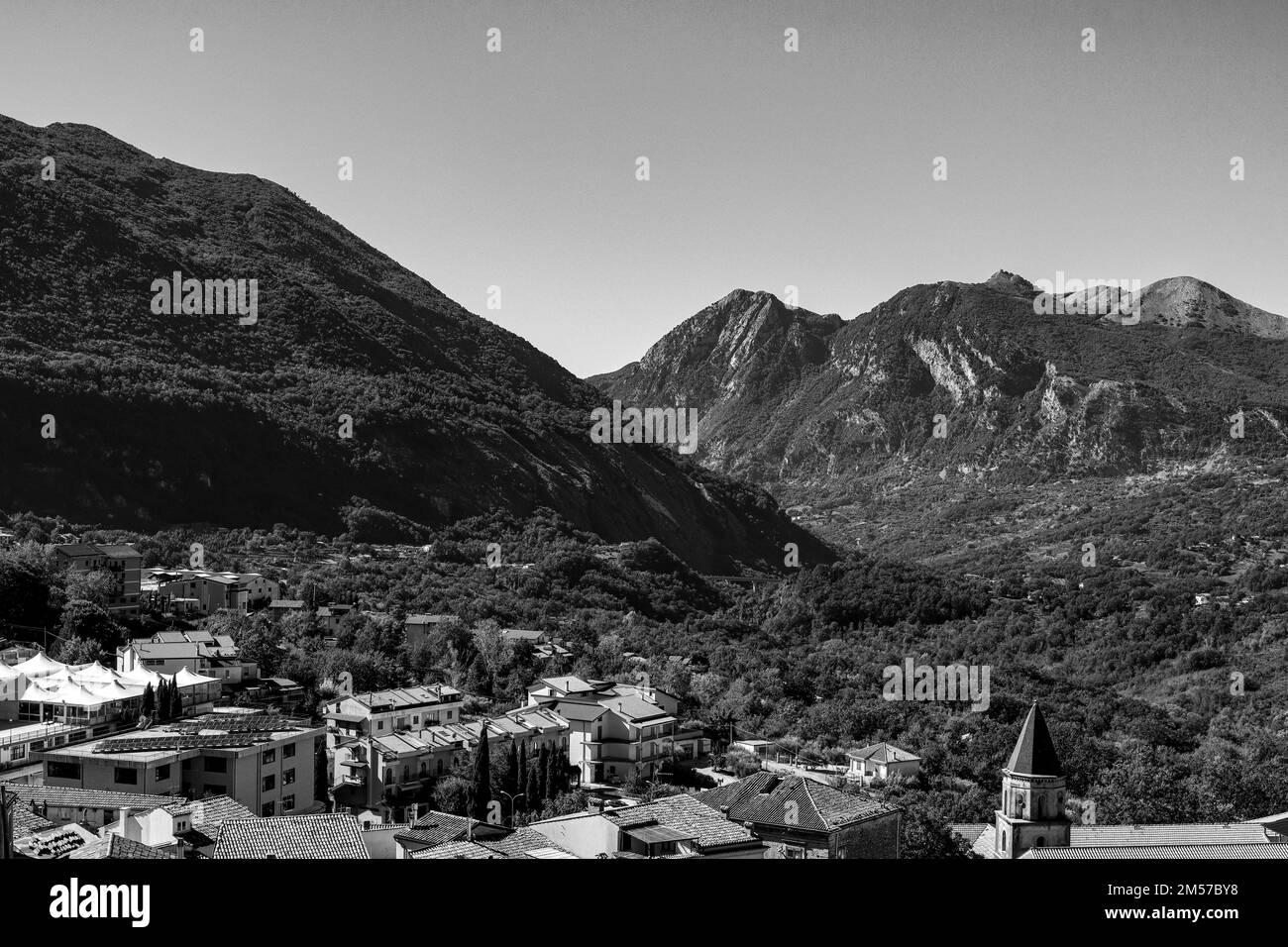 An aerial high angle of the beautiful buildings and forested mountains ...