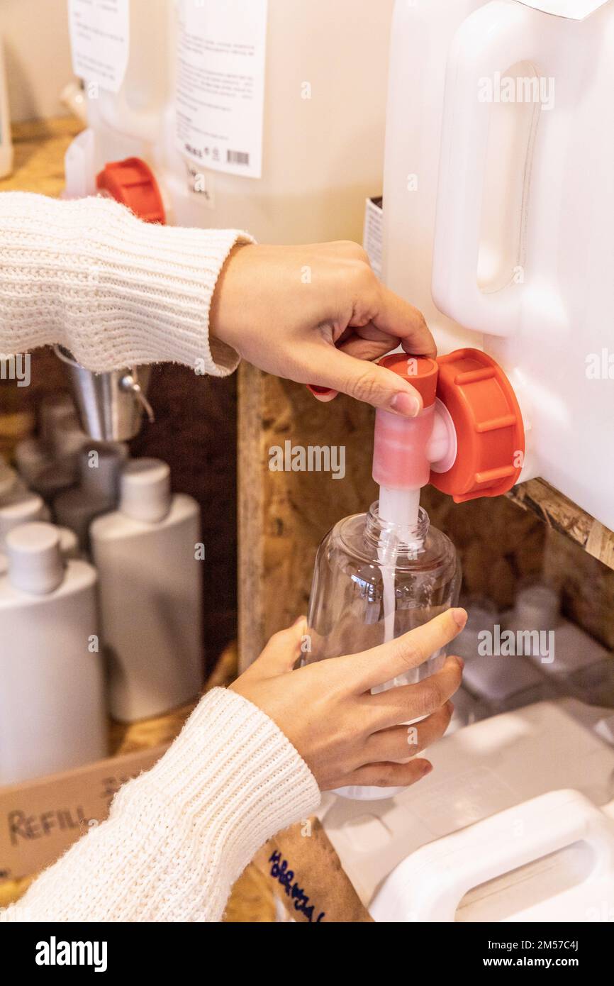 eco friendly habits hand gesture refilling detergent at zero waste shop ...