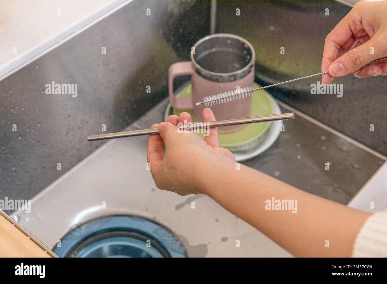 eco friendly habits hand gesture washing the stainless steel straw ...