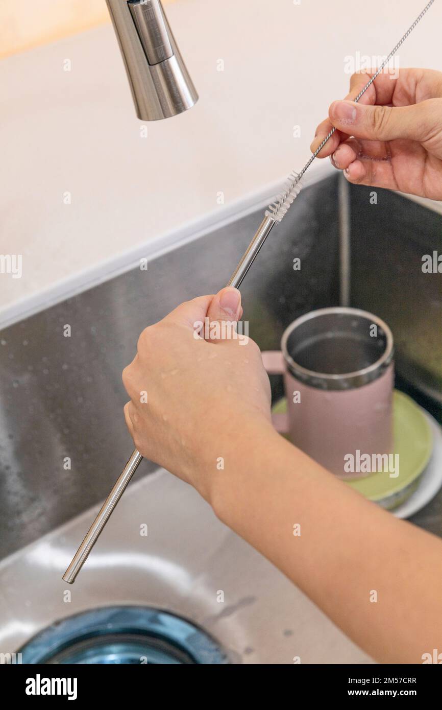 eco friendly habits hand gesture washing the stainless steel straw ...