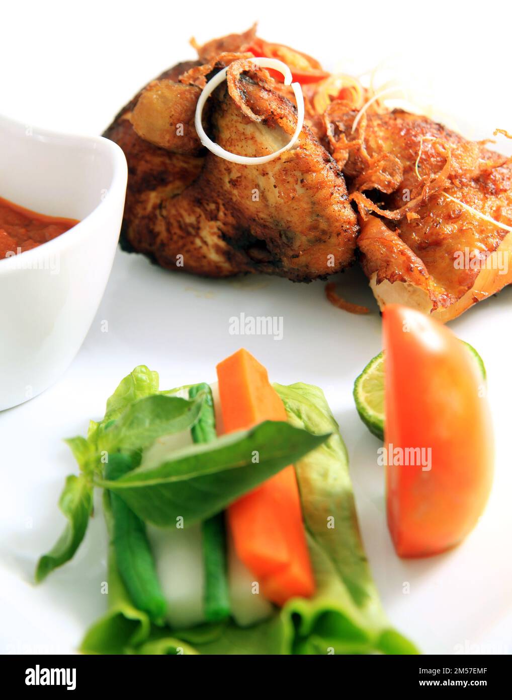 big size fried chicken portion with hot chili sauce with vegetables ...
