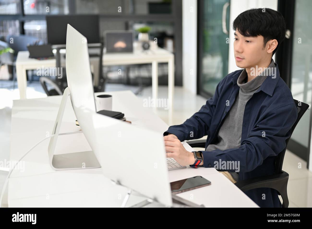 Professional and smart young Asian male web developer working at his ... Professional and smart young Asian male web developer working at his ...