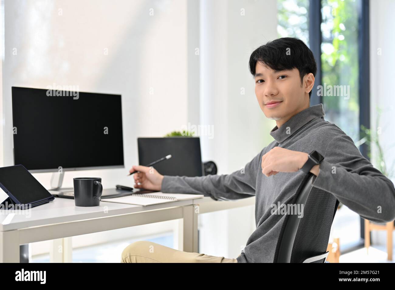 Handsome and smart young Asian male graphic designer or program ...