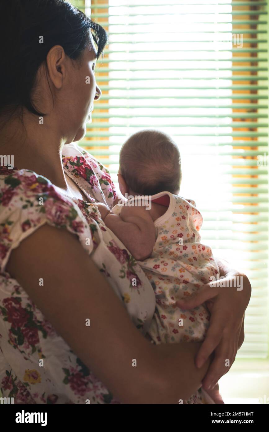 Mother and baby to the window. Floral blouse Stock Photo - Alamy