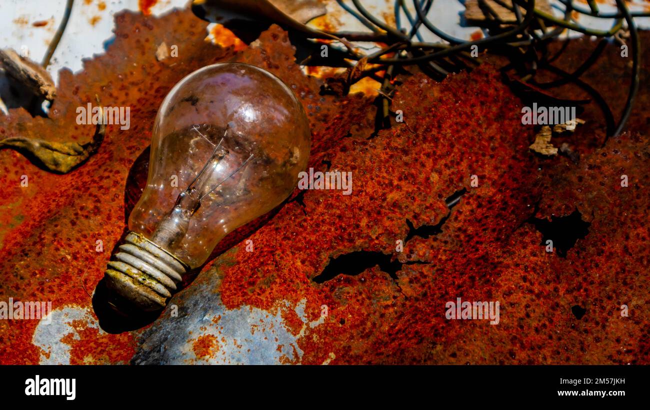 Light bulb on rusty zinc as background Stock Photo - Alamy
