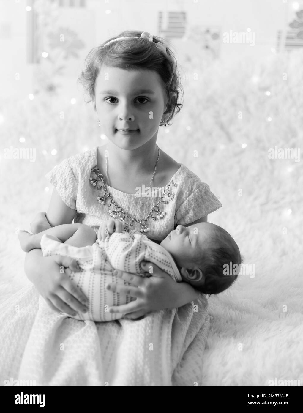 happy little girl with her newborn baby brother. black and white photo ...