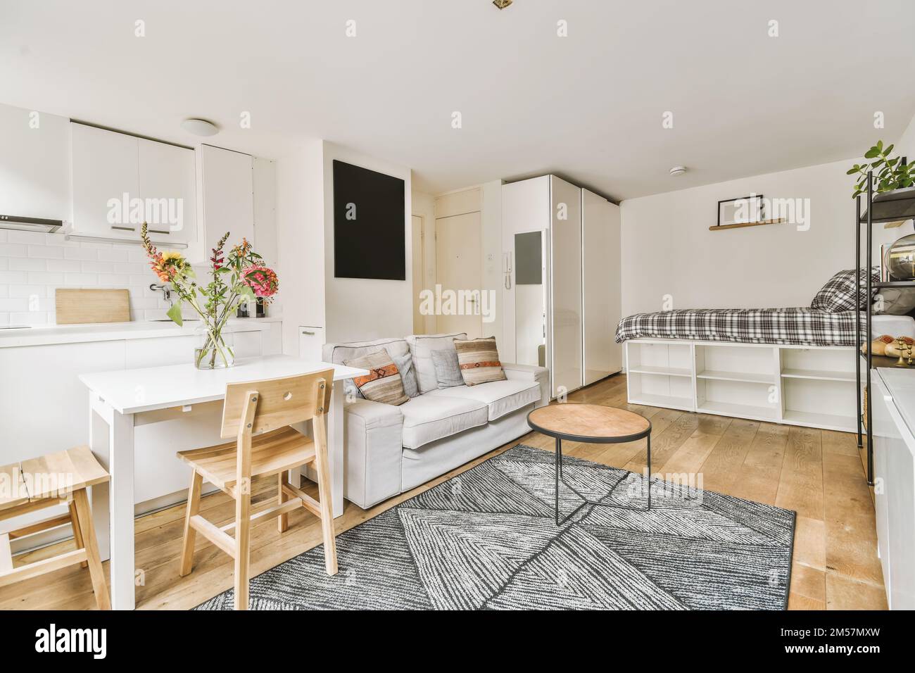 a living room with a couch, dining table and small kitchen area in the ...