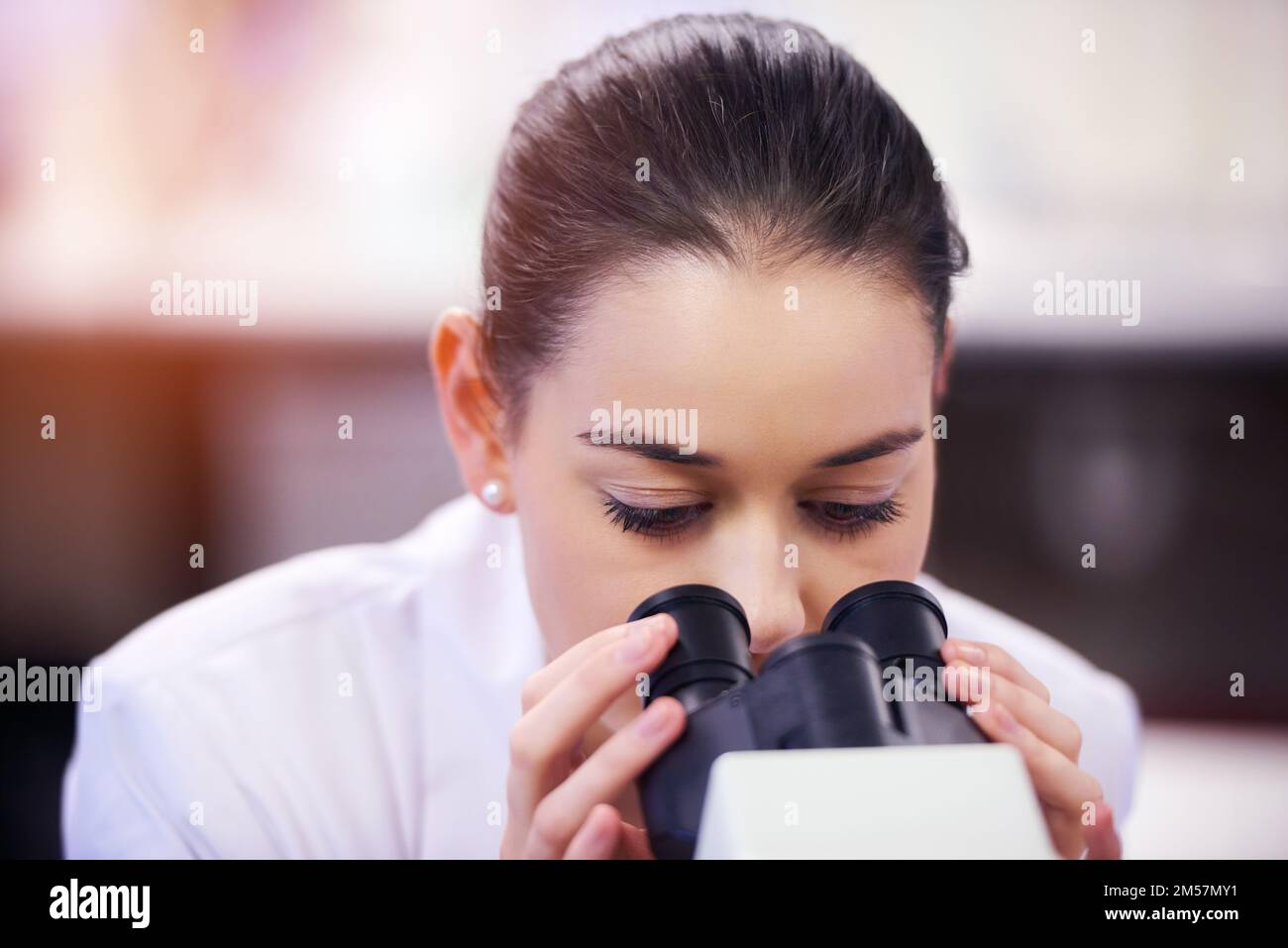 Microbiologists see everything. a young scientist using a microscope in ...
