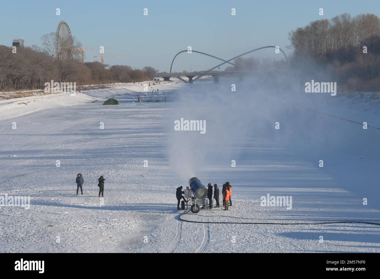 Workers use a snow gun to make artificial snow for the coming ice and ...