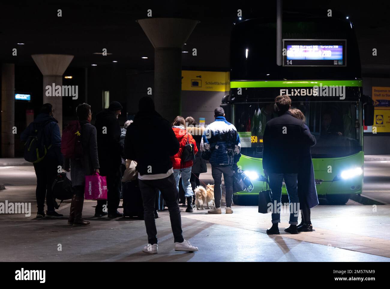 Munich, Germany. 27th Dec, 2022. Travelers stand by a bus at the ...