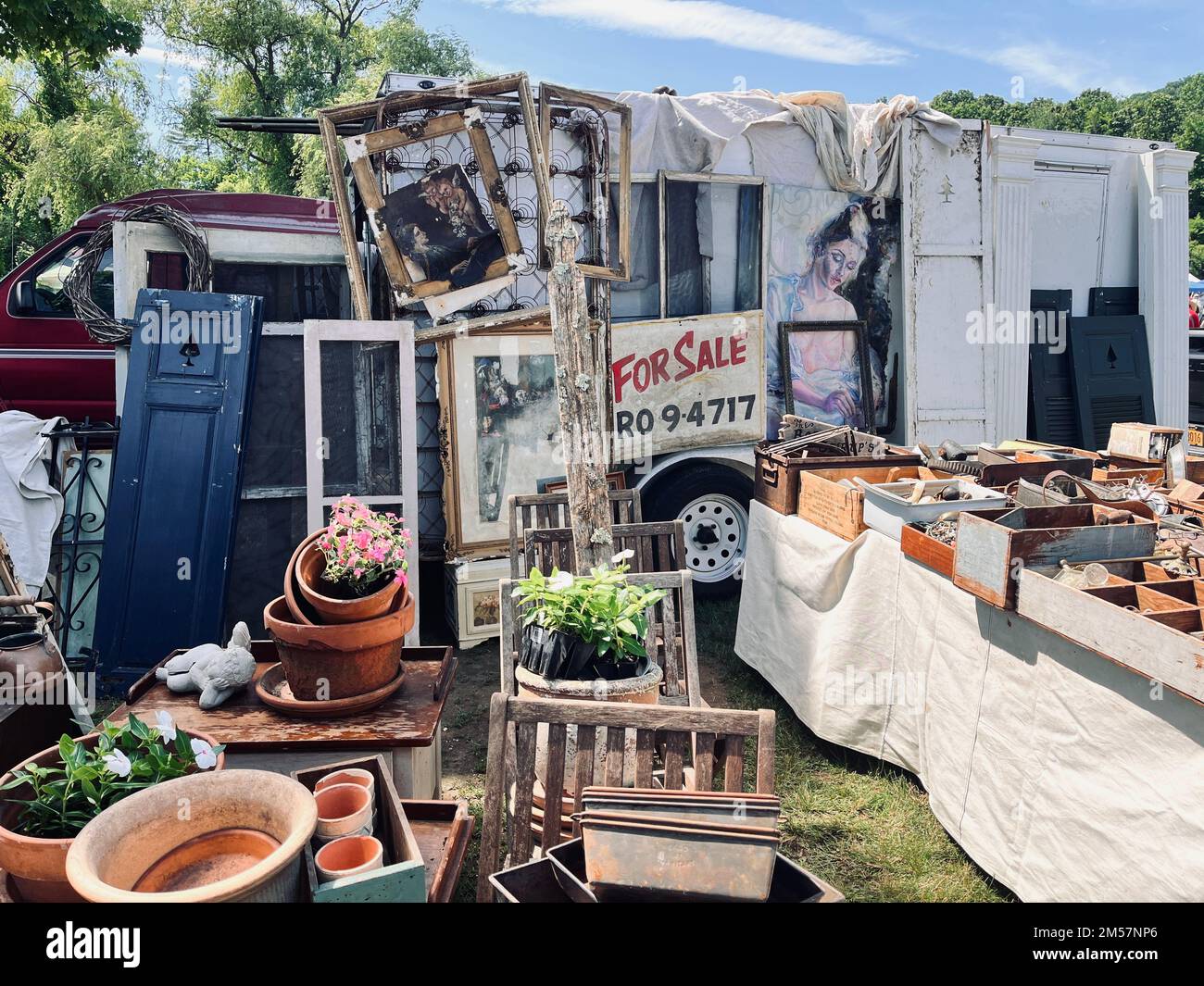 An open-air market of old vintage items including doors and paintings ...