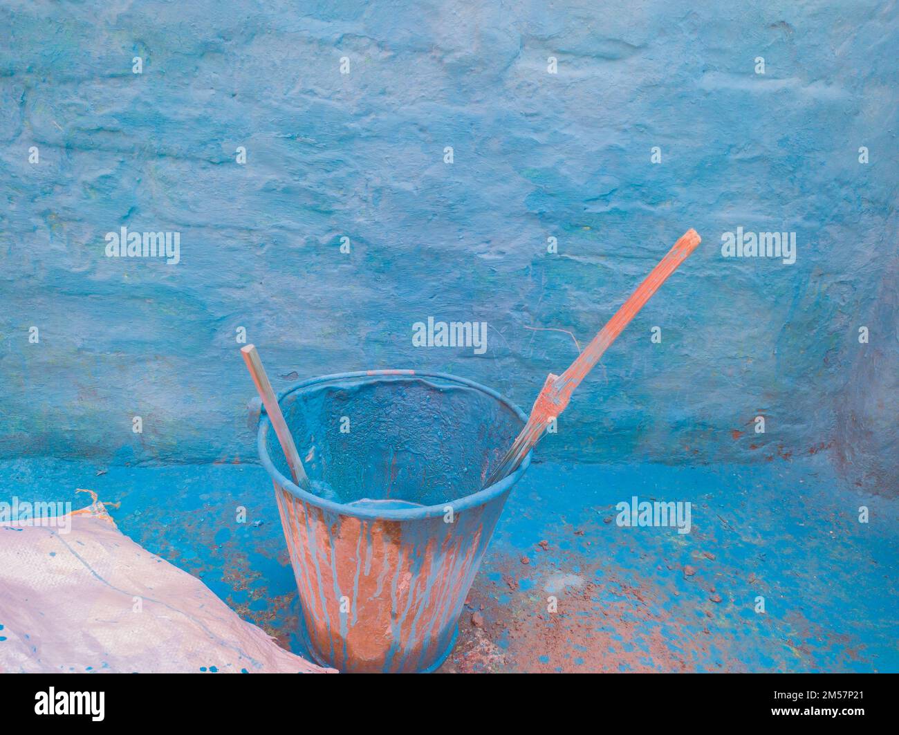 paint bucket with sky blue paint in front of half painted wall Stock ...