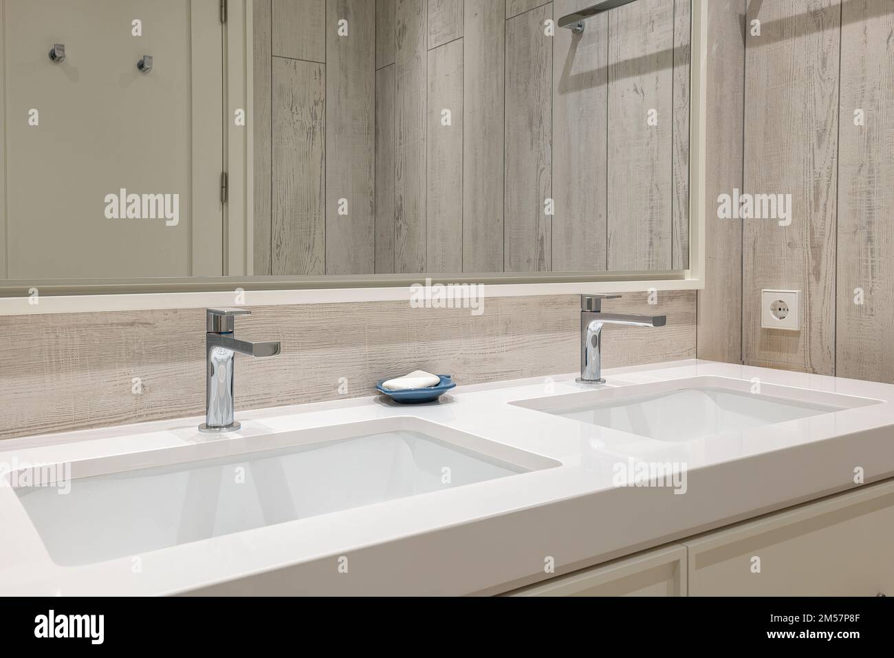 Brand new water taps and double sink in luxury bathroom with large ...