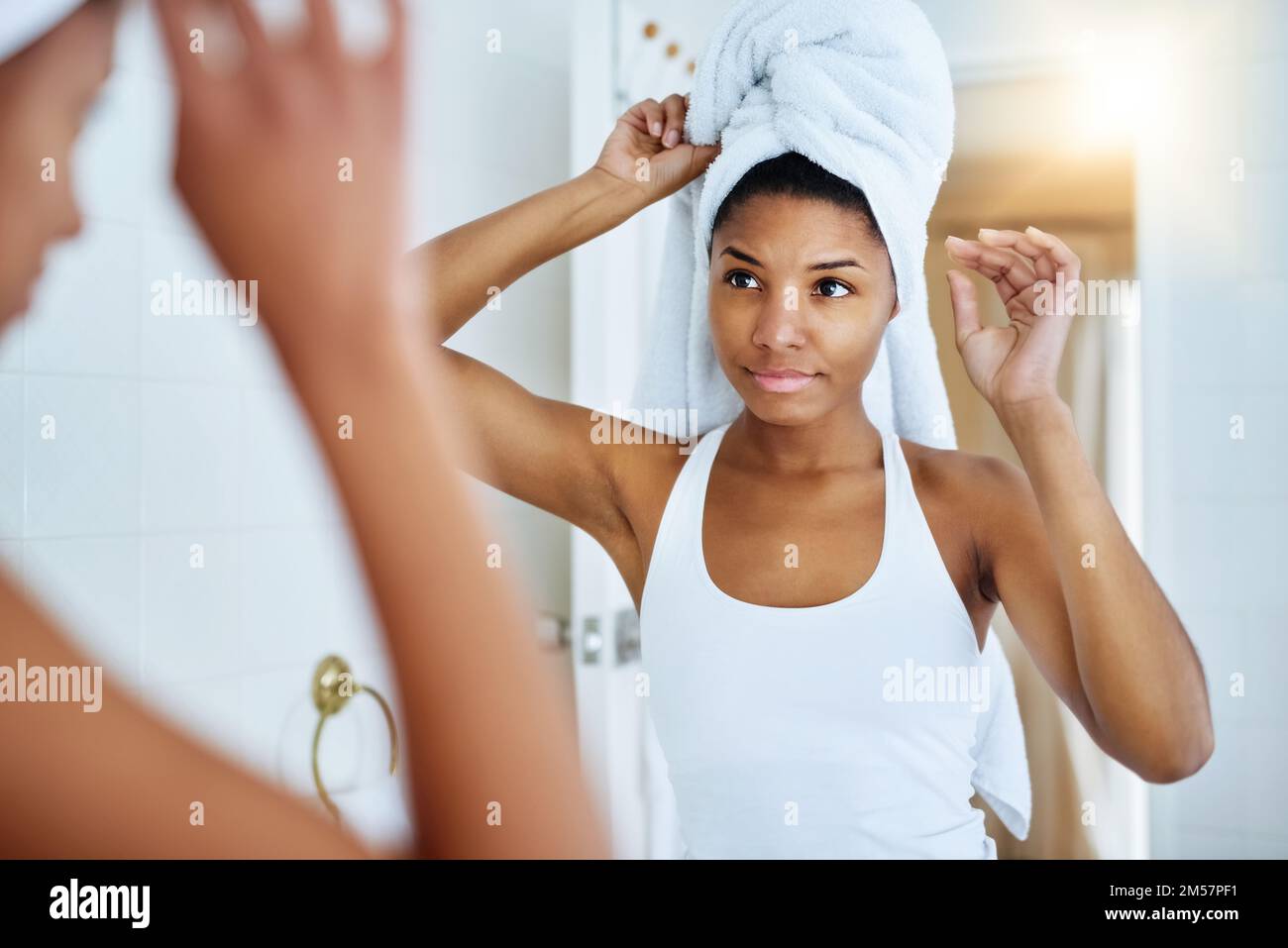 Keeping herself looking good. an attractive young woman going through ...