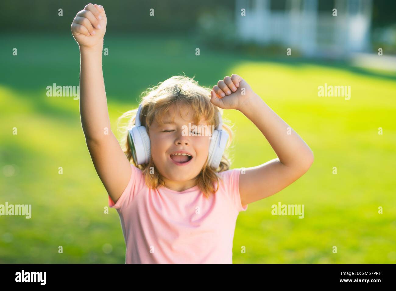 Singing and dancing children. Happy child enjoys listens to music in ...