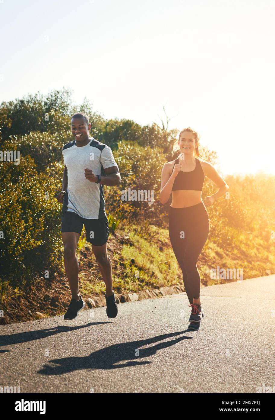 Just keep running. a fit young couple going for a run outdoors Stock ...