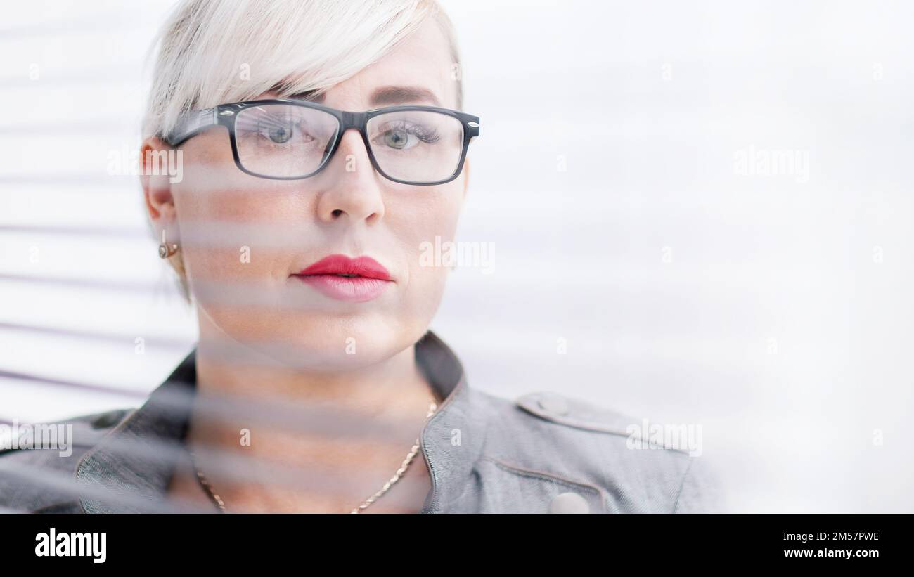 close up. business woman looks somewhere through the office window ...