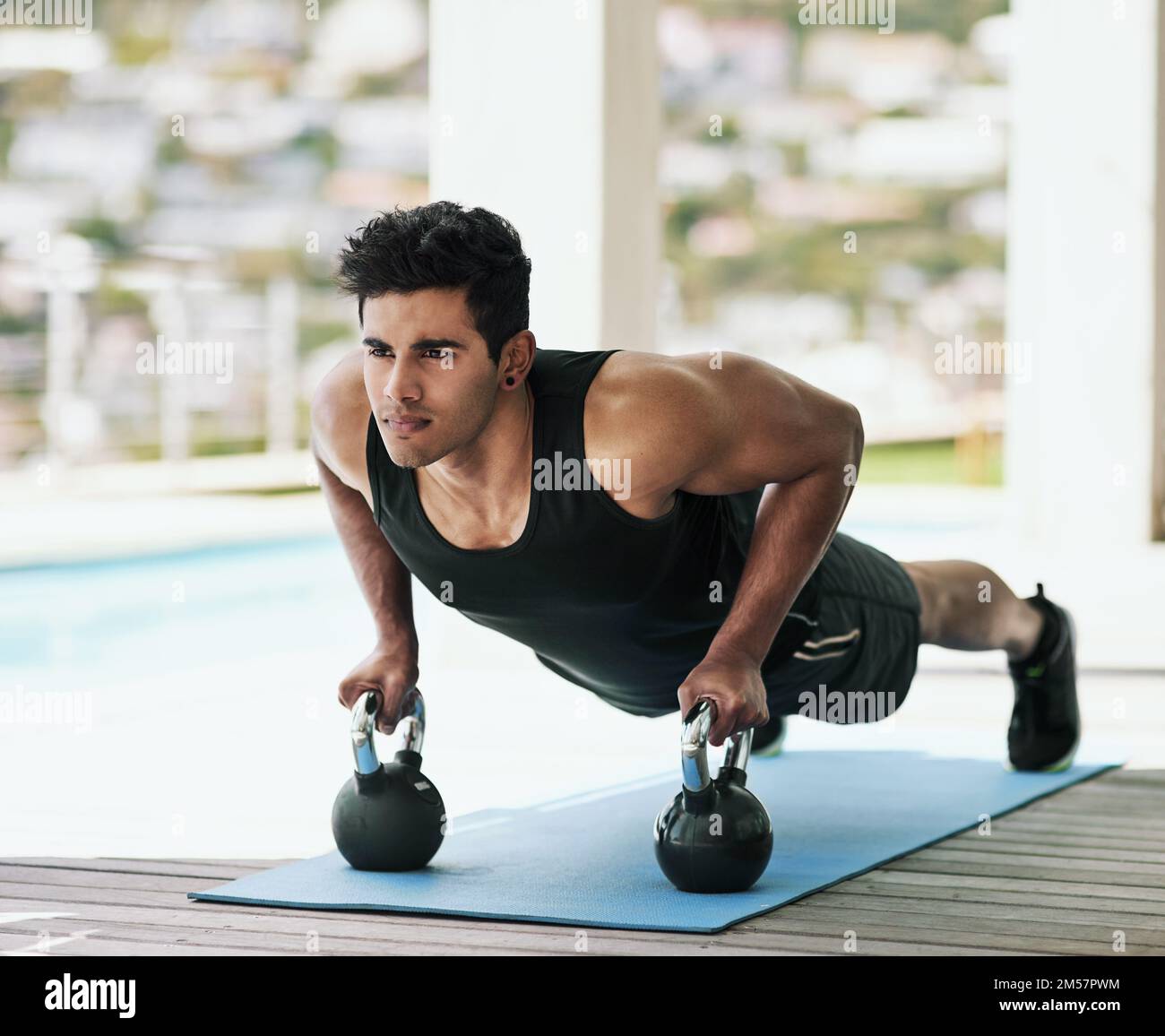 Pushing himself a little further every day. a young man doing pushups ...