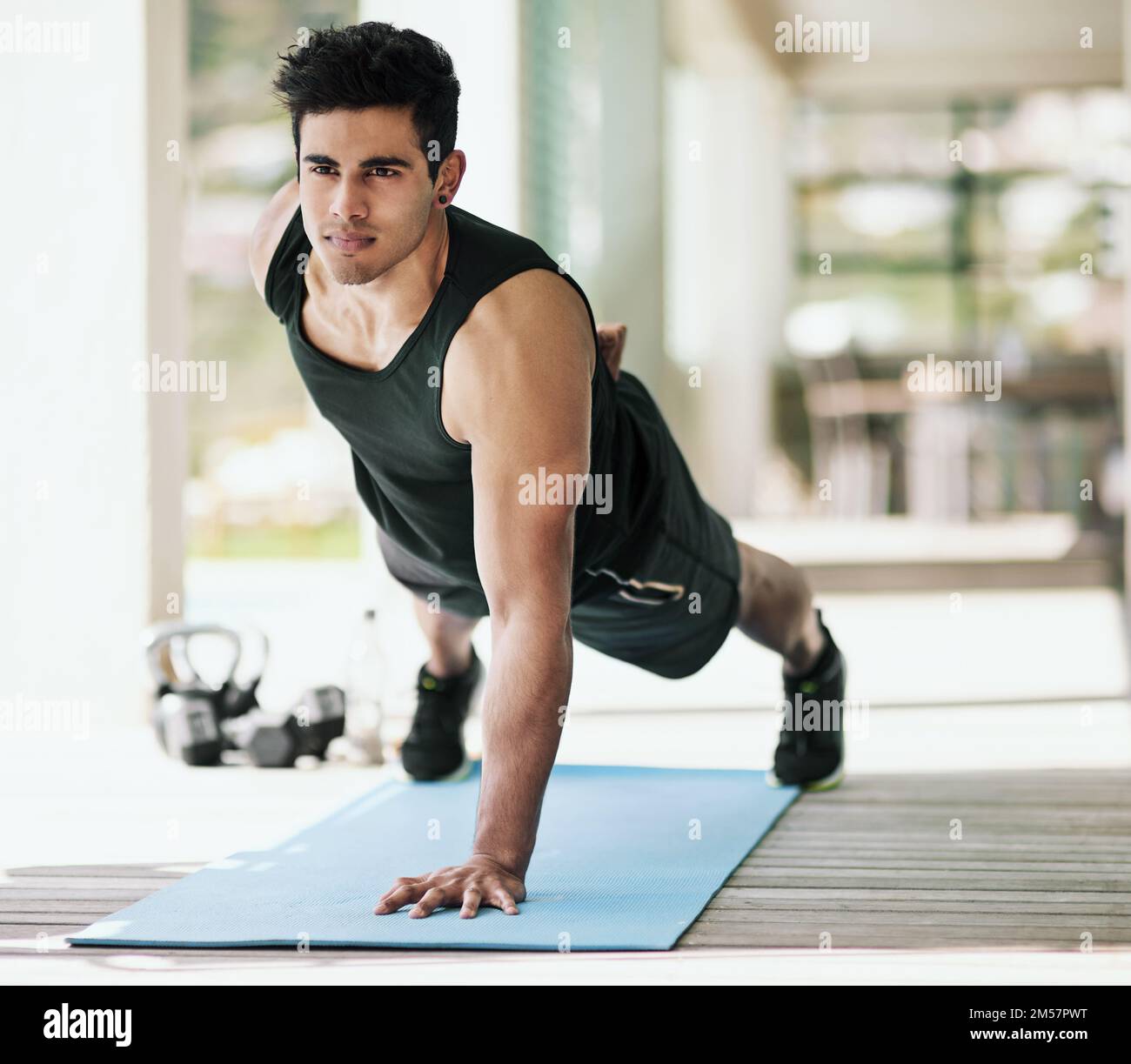 Im a lean, mean training machine. Portrait of a young man doing pushups ...