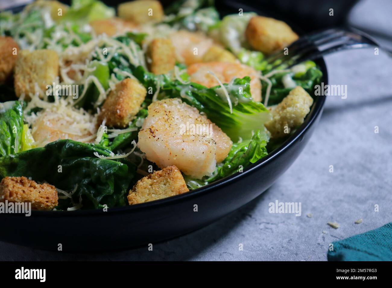 close up of Cesar salad with grilled shrimp, croutons and parmesan ...