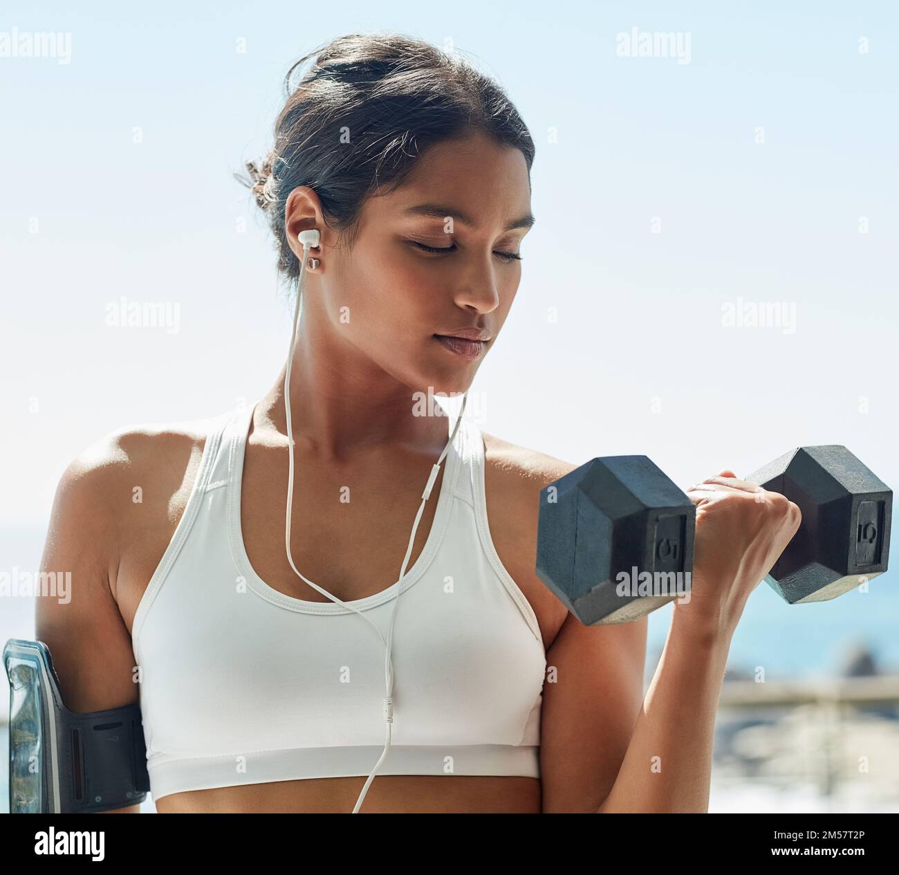 Youre stronger than you think. a young woman using dumbbells in her ...