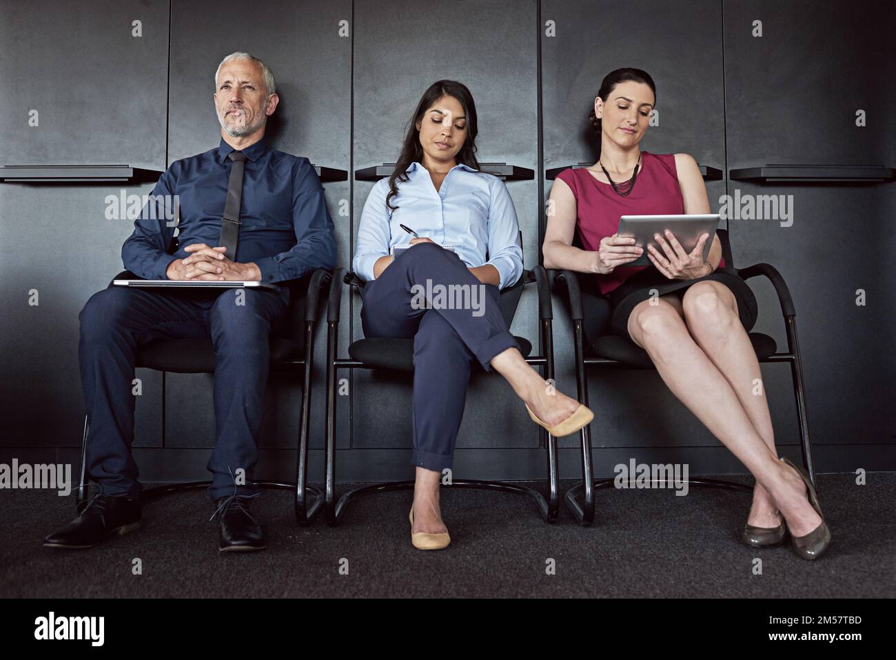 Its interview time. Full length sshot of three people sitting in line ...