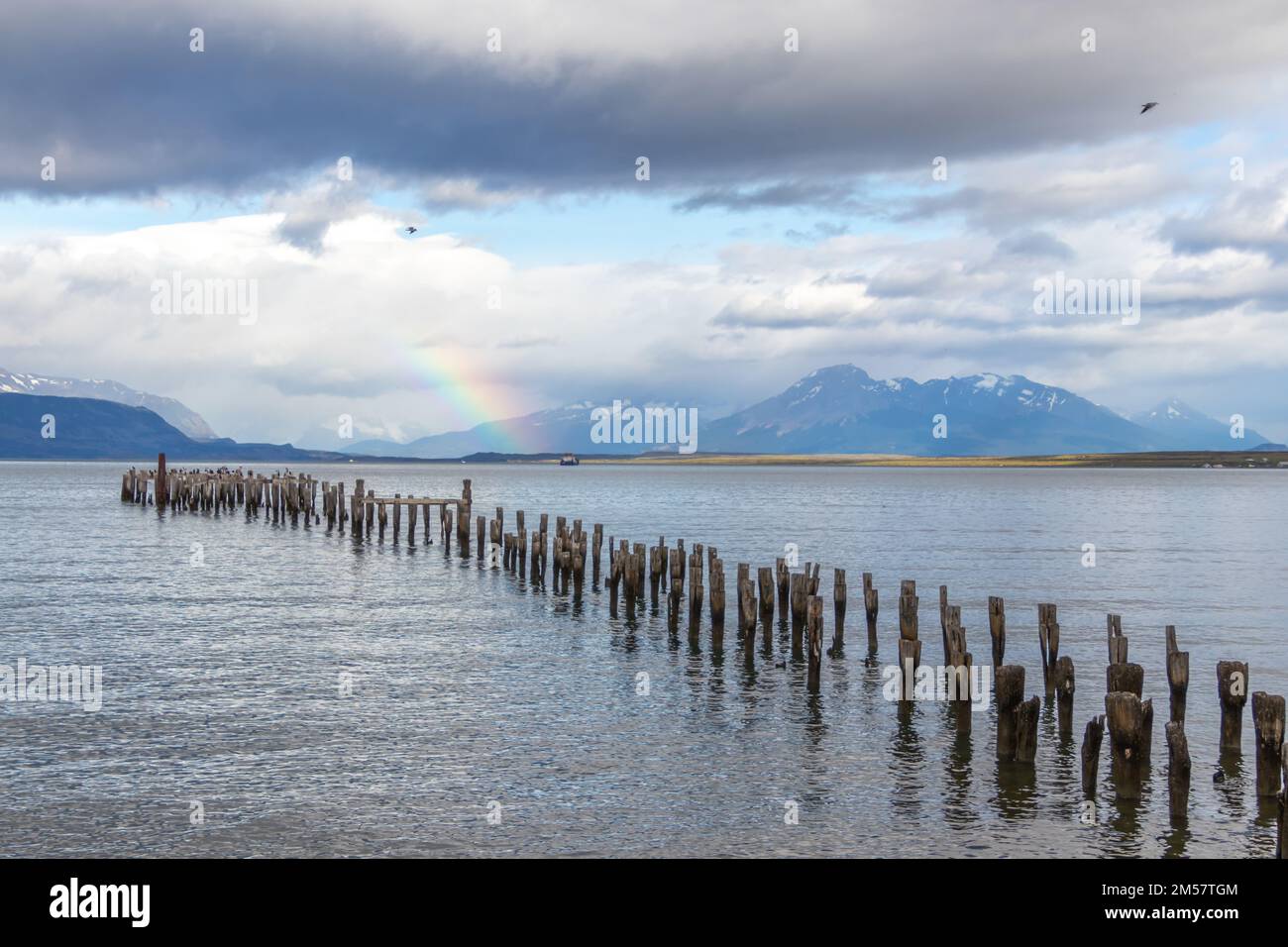 Rainbow over the ocean surrounded by mountains in Puerto Natales ...