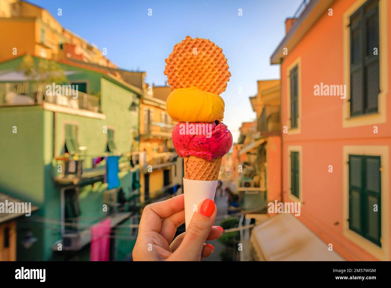 Woman s hand holding an artisanal gelato with a cookie and a view of ...
