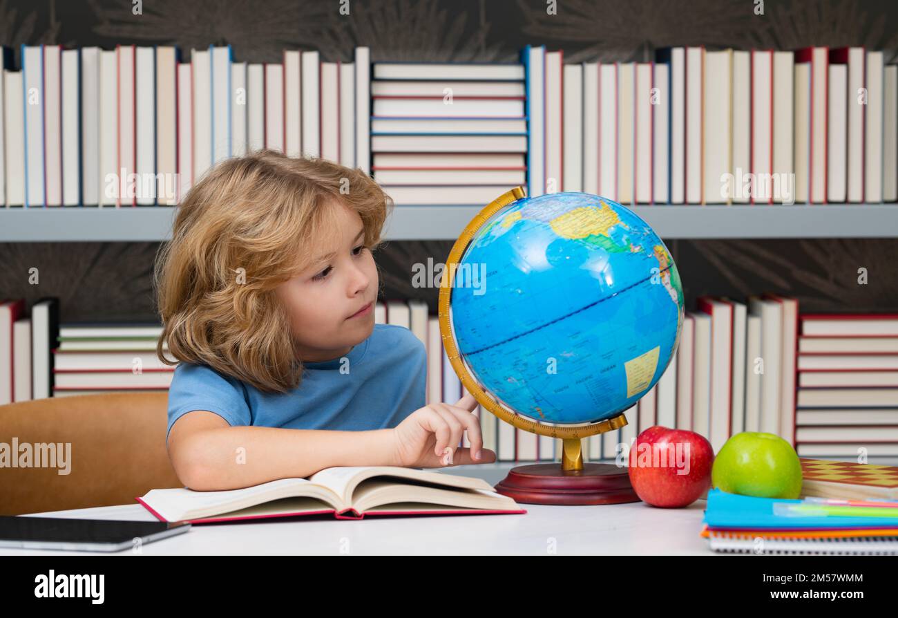Pupil looking at globe in library at the elementary school. Nerd school ...