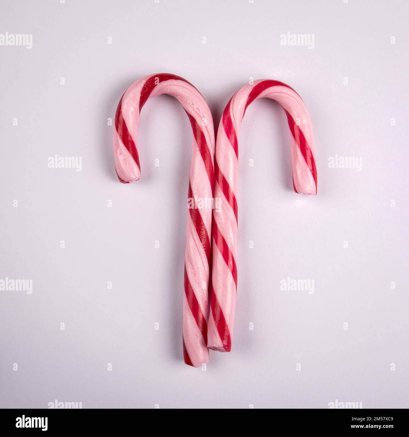 Two red candy canes on a white background Stock Photo - Alamy