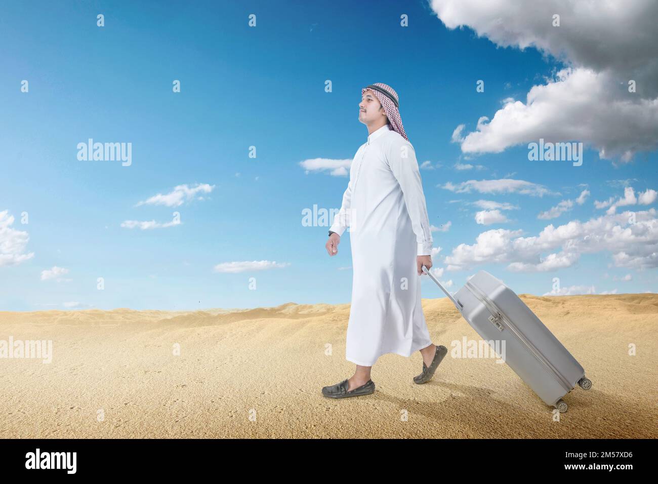 Arab man wearing keffiyeh and agal walking with a suitcase for ...