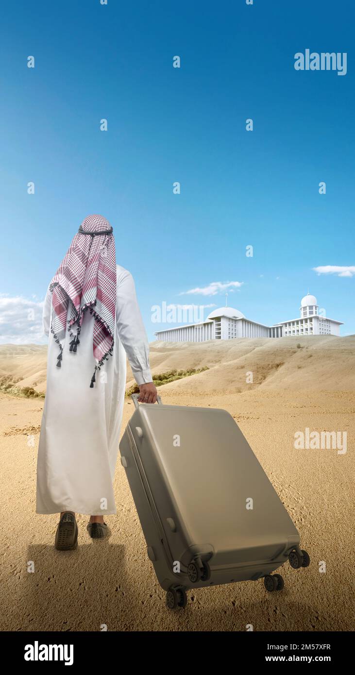Rear view of an Arab man wearing keffiyeh and agal walking with a ...