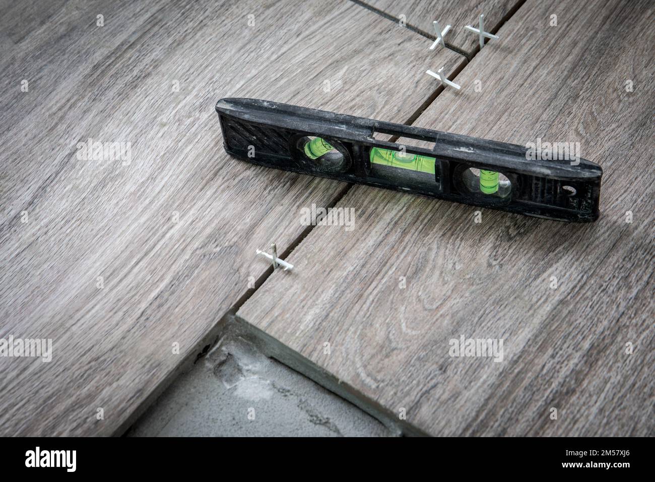 Black spirit level on tiles. Tiling works, renovation and construction ...