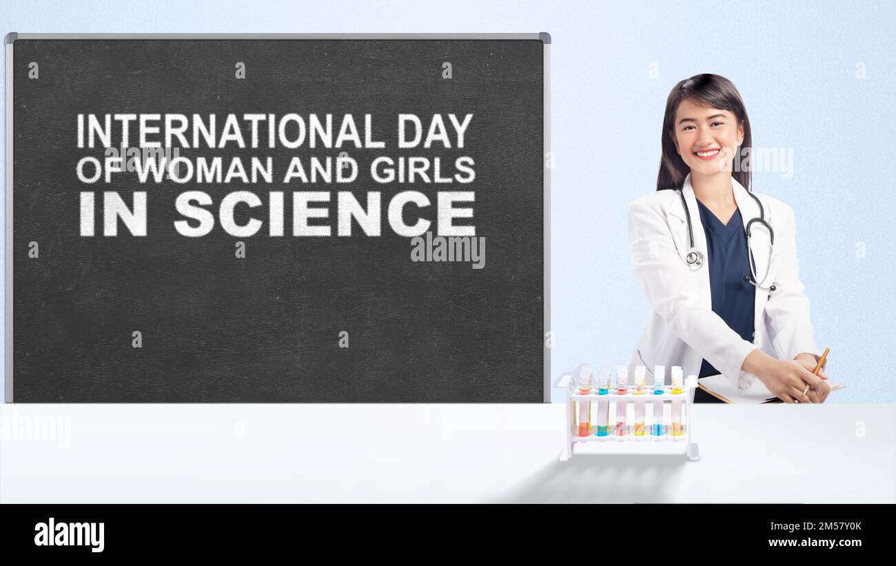 Asian scientists holding a clipboard with International Day of Women ...