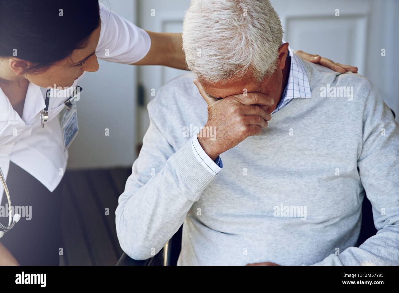Caregiving with compassion. a caregiver consoling a depresed senior man ...