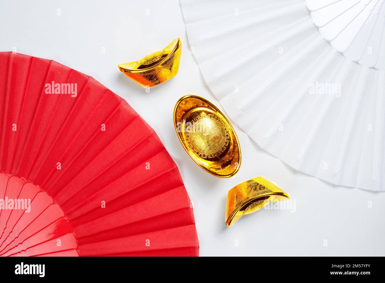 Red and white Chinese fan with Chinese gold ingots on white background ...