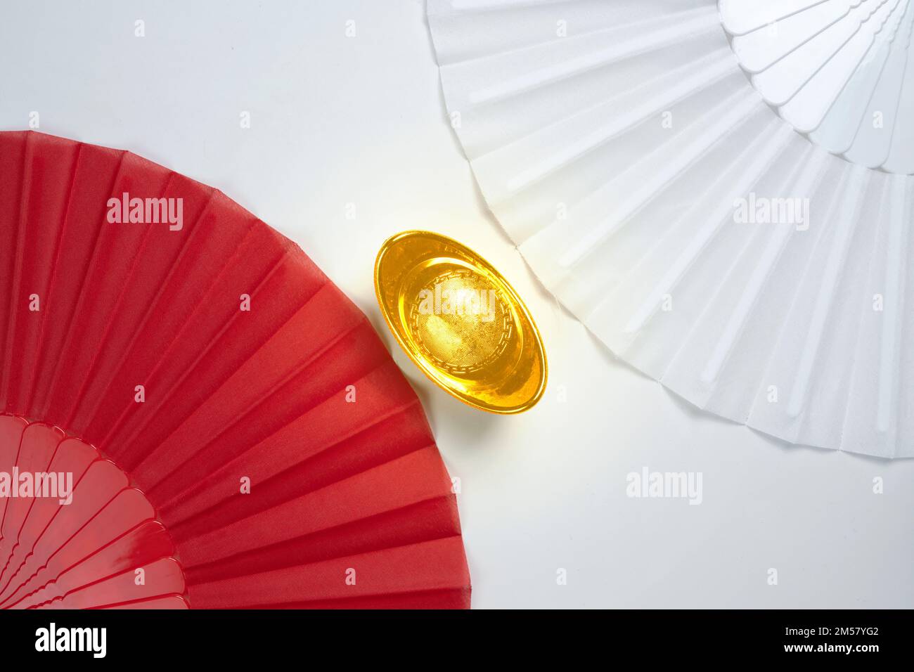 Red and white Chinese fan with Chinese gold ingots on white background ...