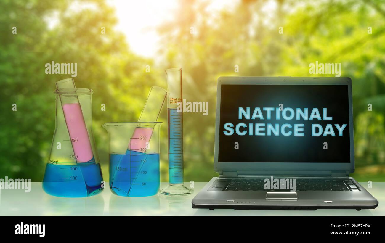 Colorful chemicals in laboratory glassware and laptop with blurred ...