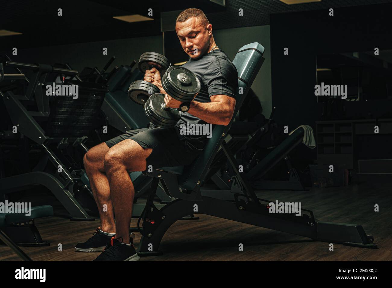 Male with sport body lifting dumbbells at the gym Stock Photo - Alamy