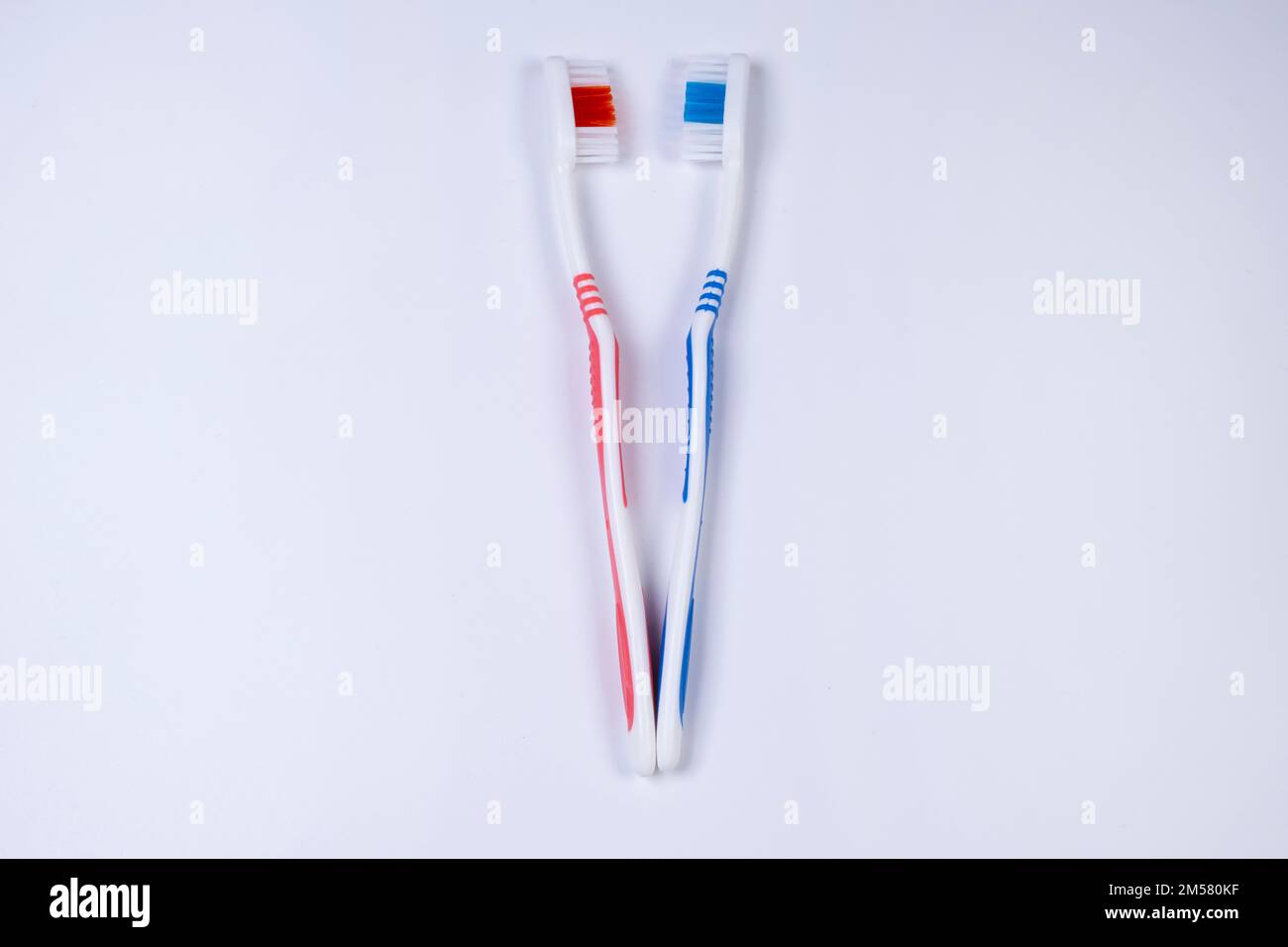 two toothbrushes, red and blue on a white background, the concept of a ...