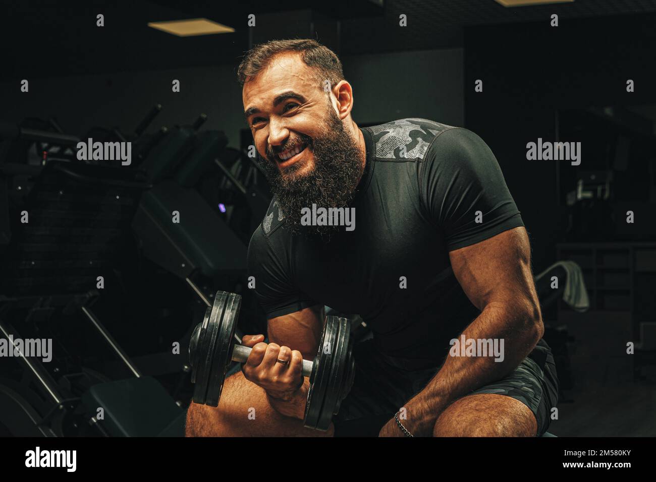 Male with sport body lifting dumbbells at the gym Stock Photo - Alamy