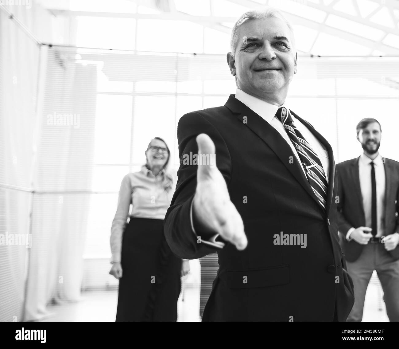 smiling businessman holding out his hand for a handshake Stock Photo ...