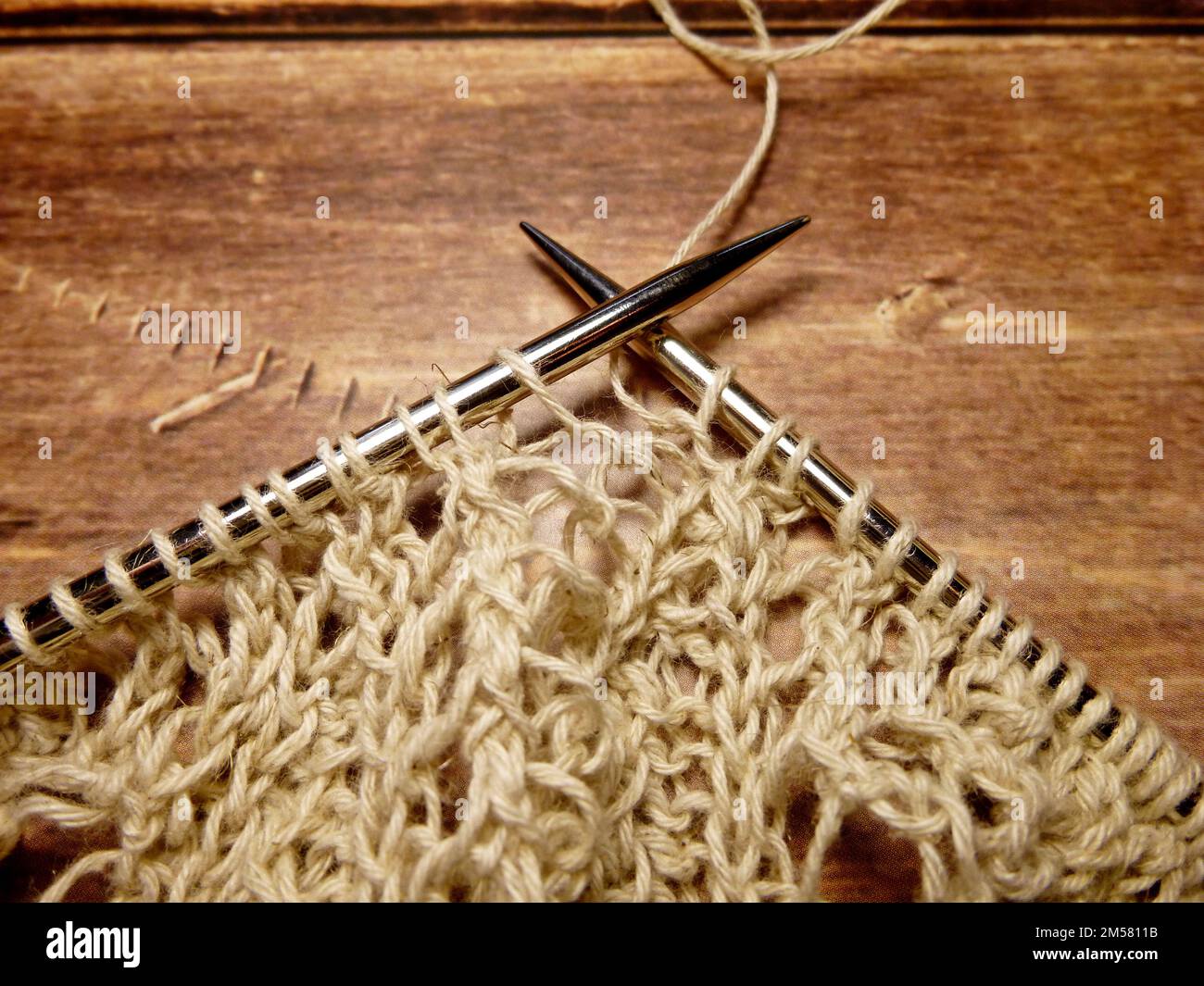 Openwork tablecloth in the process of knitting. Knitting needles, loops ...