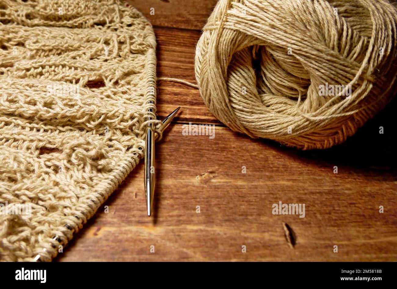 Openwork tablecloth in the process of knitting. Knitting needles, loops ...