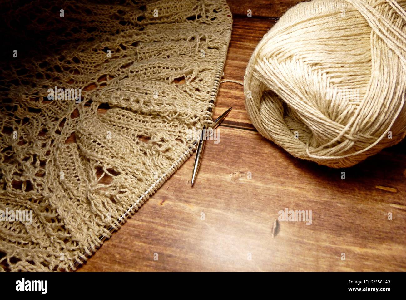Openwork tablecloth in the process of knitting. Knitting needles, loops ...