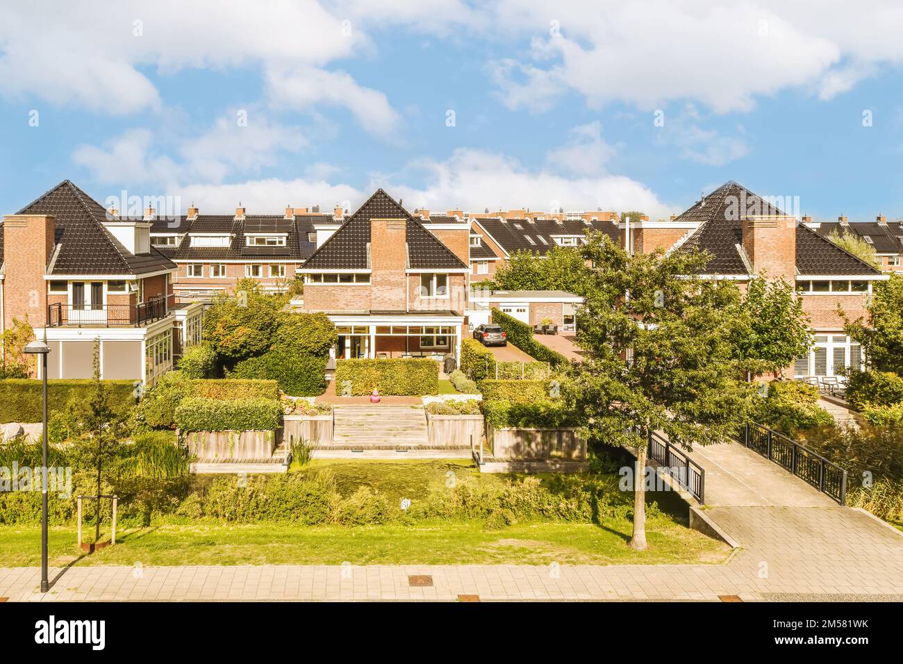some houses in the middle of an area with green grass and trees on both ...