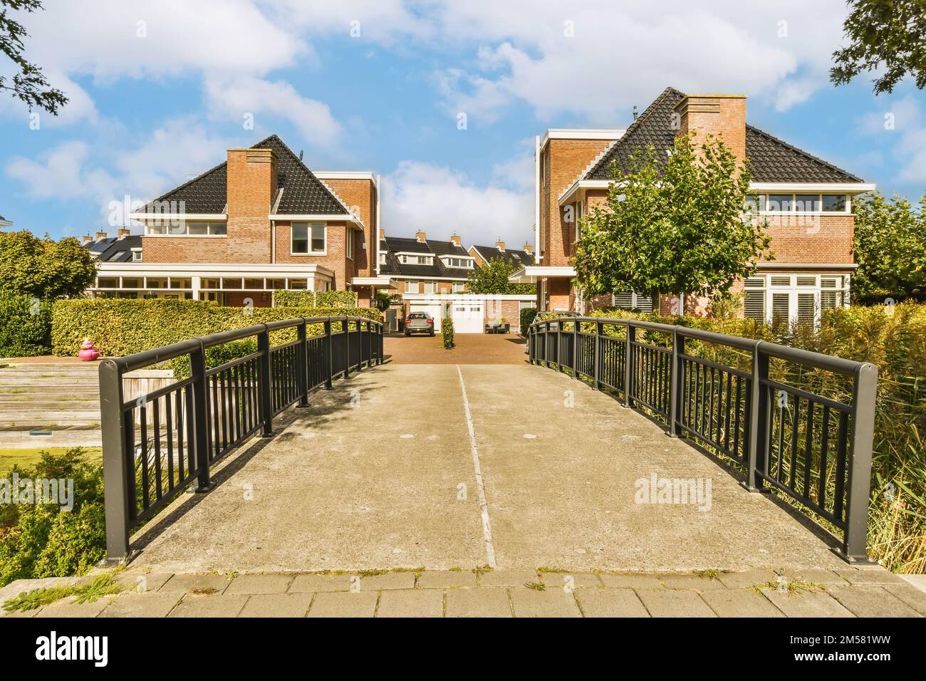some houses in the background and a walkway leading to them with trees ...