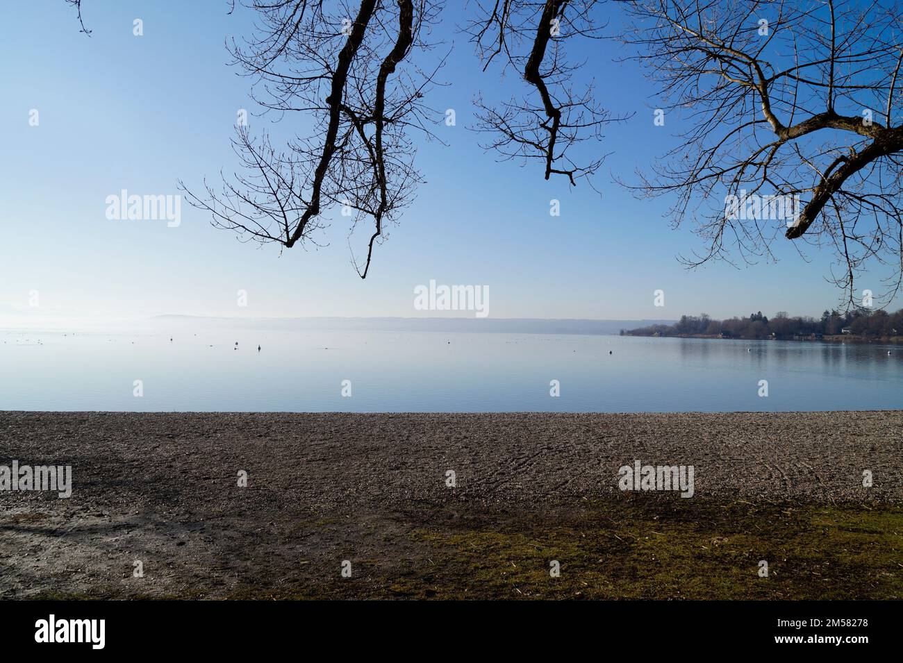 wintery peaceful scenery with lake Ammersee in Herrsching in Bavaria ...