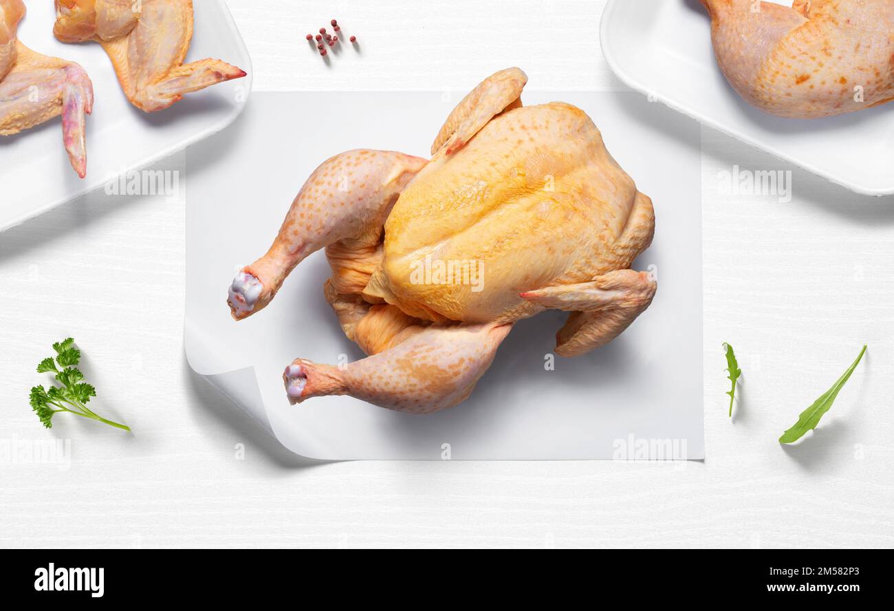 Whole chicken on a flat lay of a kitchen with chicken pieces from above ...